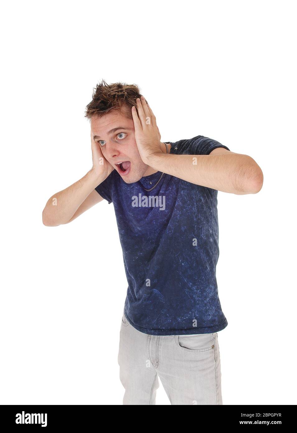 A close up image of a young man standing and screaming with both hand ...