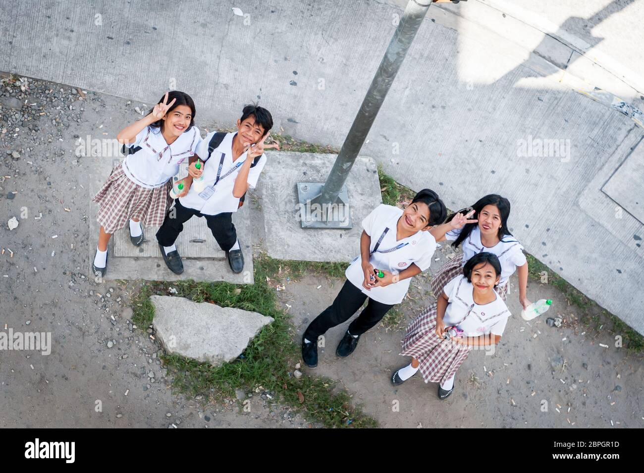 Filipino school children notice me photographing them as they cross a ...