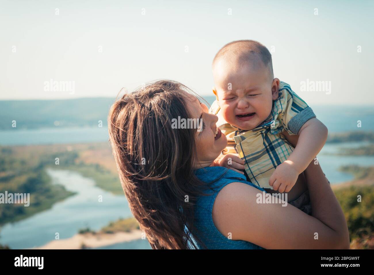 mother and crying toddler son on nature background Stock Photo - Alamy