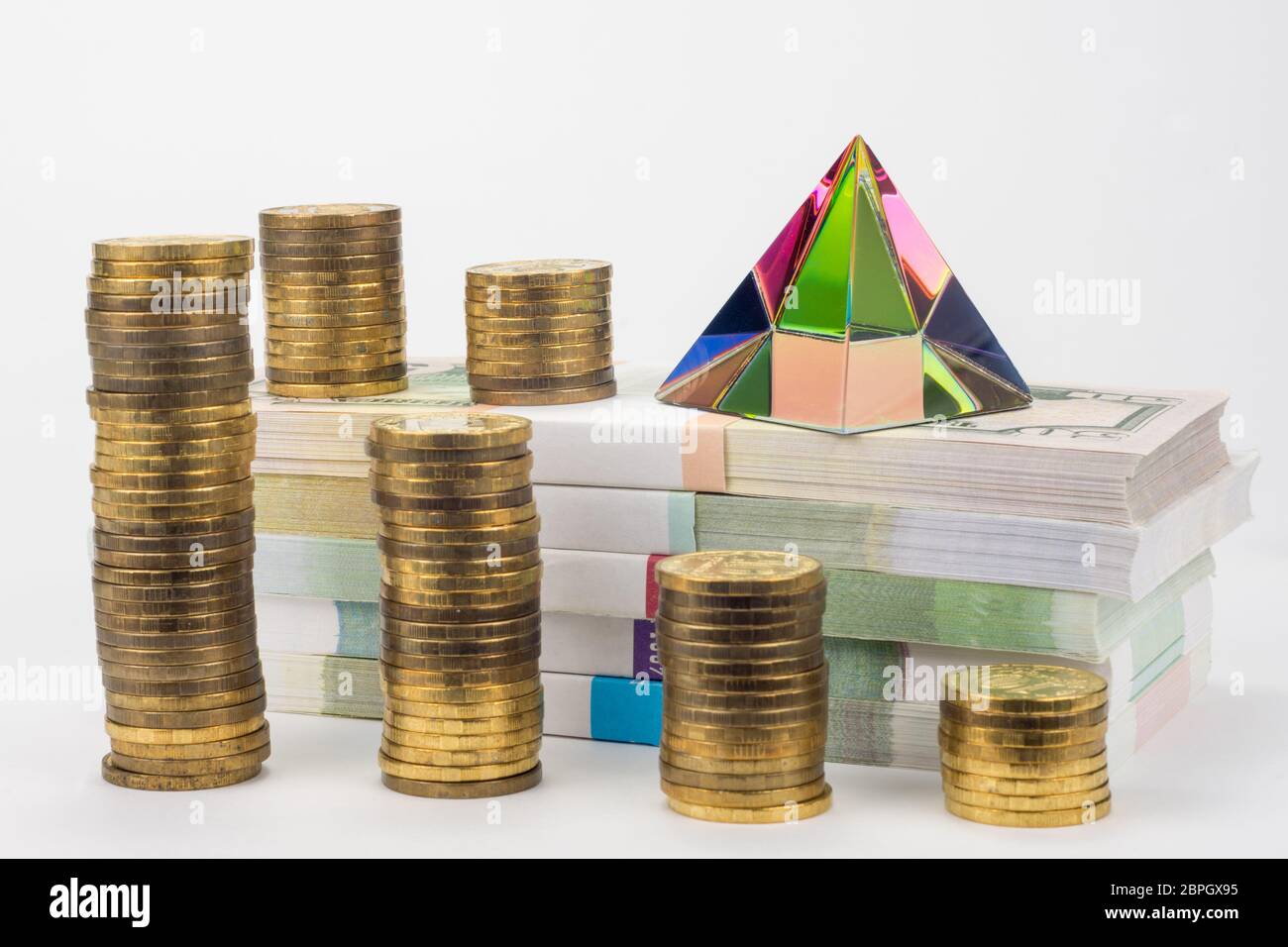 Stacks of coins, bundles of notes and a glass pyramid Stock Photo - Alamy