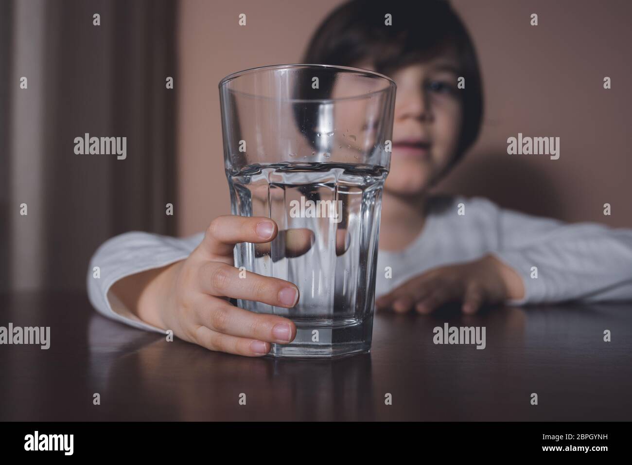Child with big water glass Stock Photo - Alamy