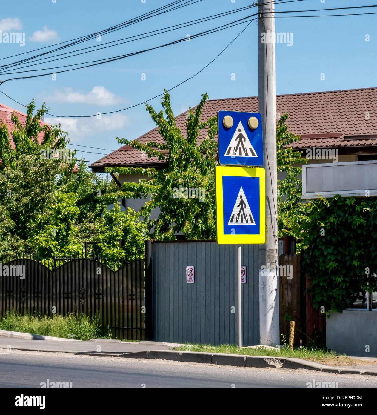 Pedestrian crossing traffic sign. Blue sign with a white triangle and a man crossing the street ...