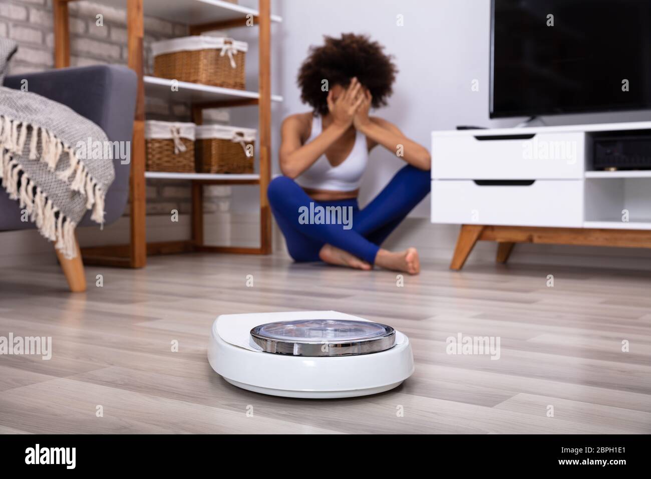 Weighing Scale In Front Of Crying Young Woman Sitting In The Living ...