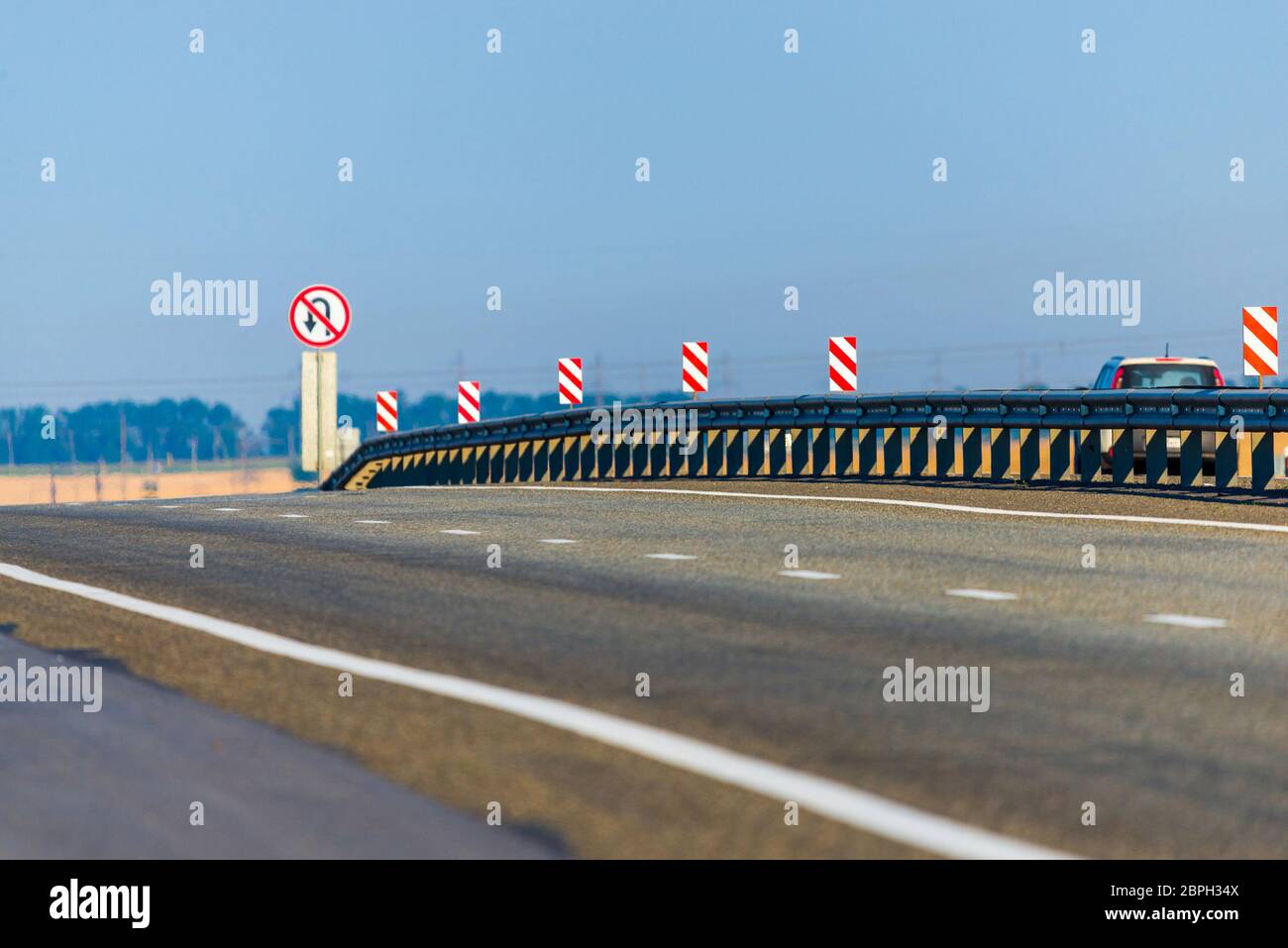 A metal separator of directions on an asphalt road between cities. Road ...