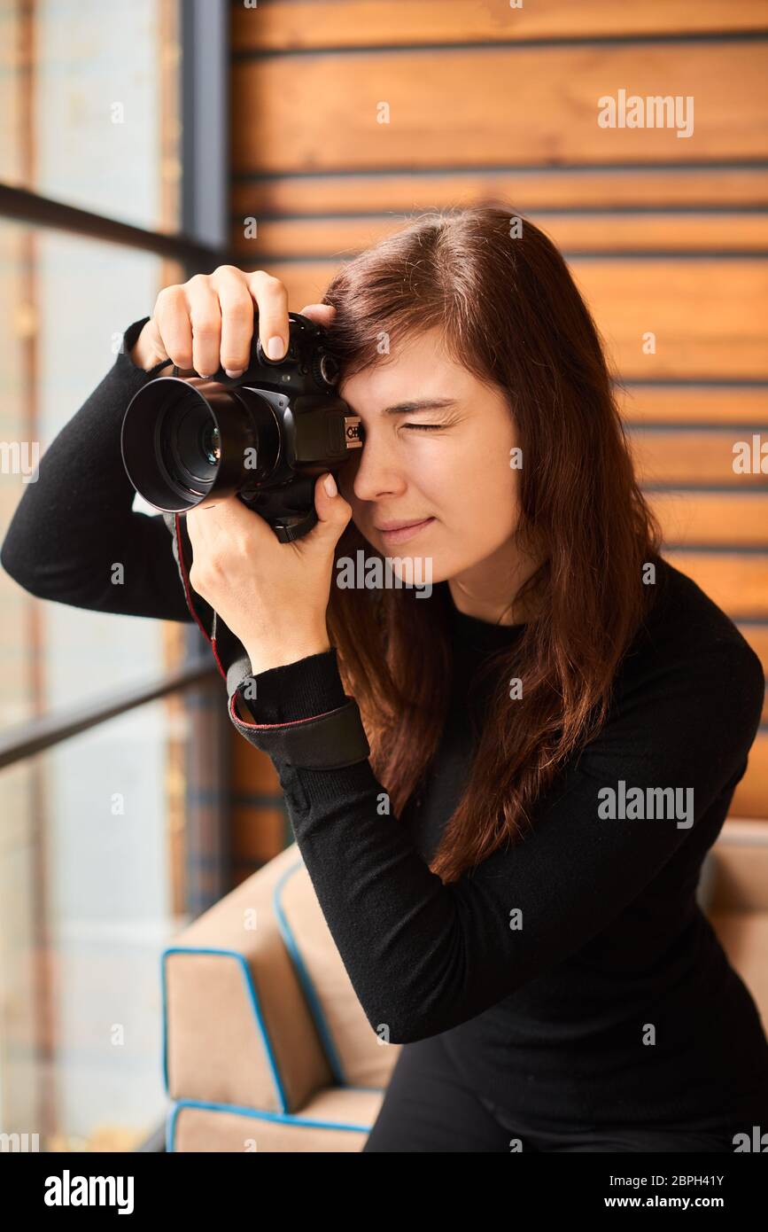 Young photographer with camera taking photo on professional photo shoot ...