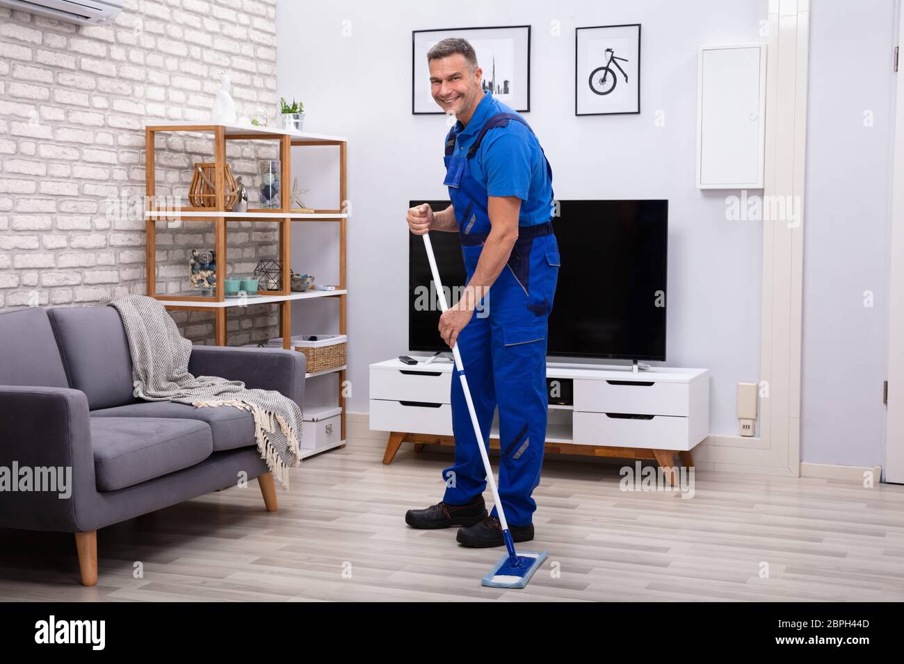 Mature Male Janitor Cleaning Floor With Mop At Home Stock Photo - Alamy