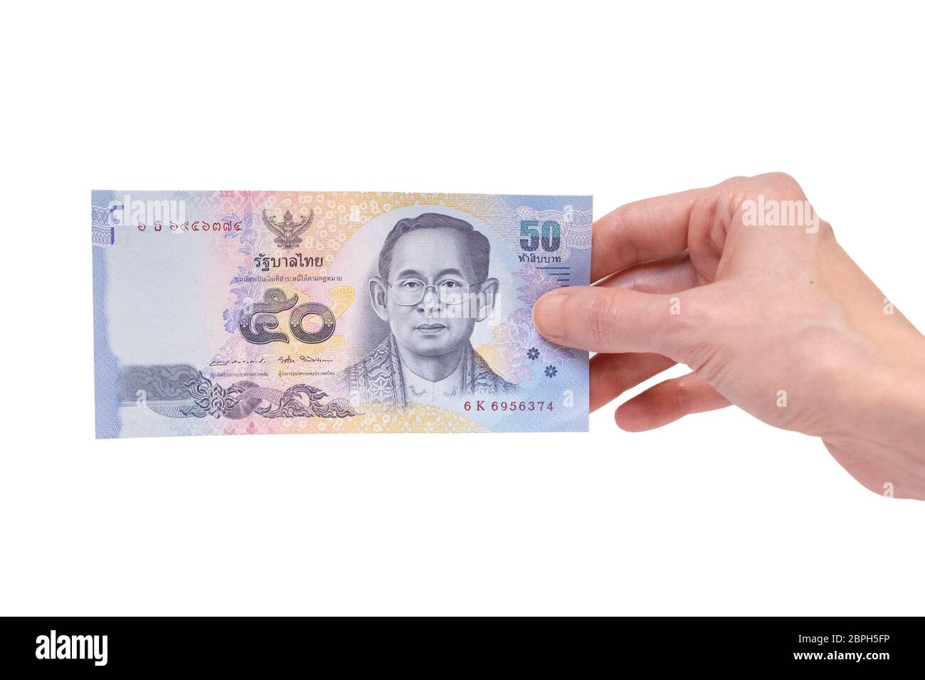Female hand holding a 50 Thai Baht banknote isolated on a white ...