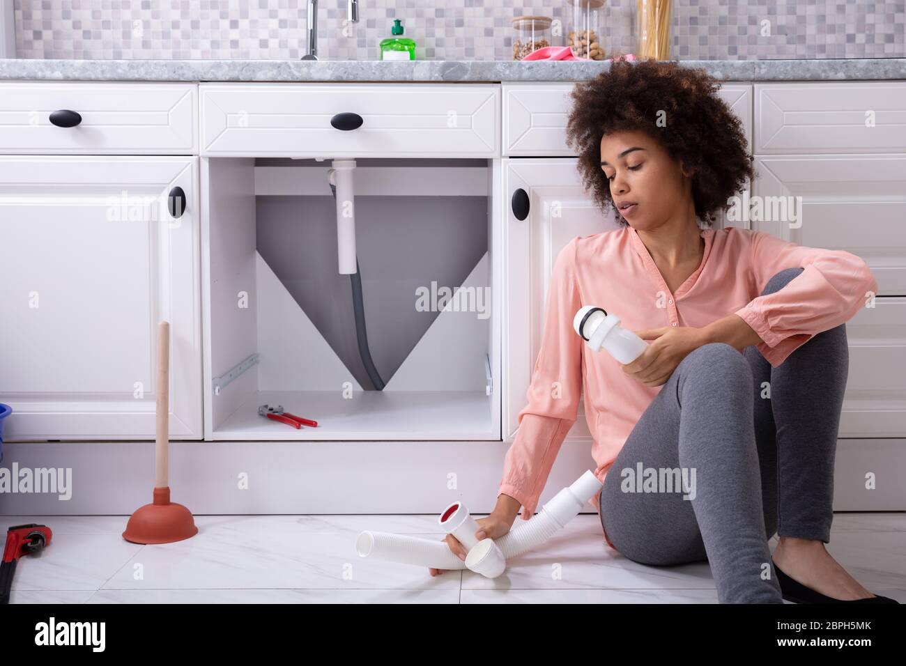 Disappointed African Young Woman Holding Broken Sink Pipe In Hand ...