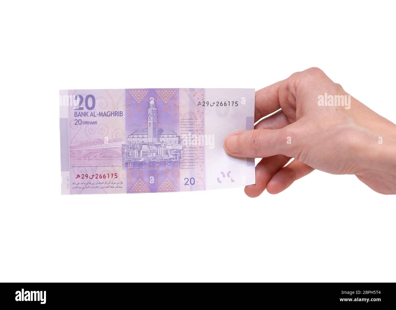 Female hand holding a 20 Moroccon Dirham banknote isolated on a white ...