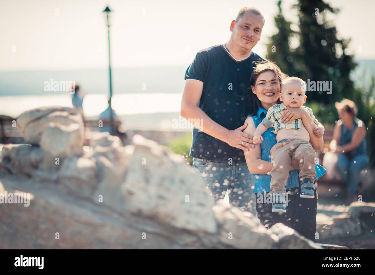 Happy family with baby near the fountain Stock Photo - Alamy