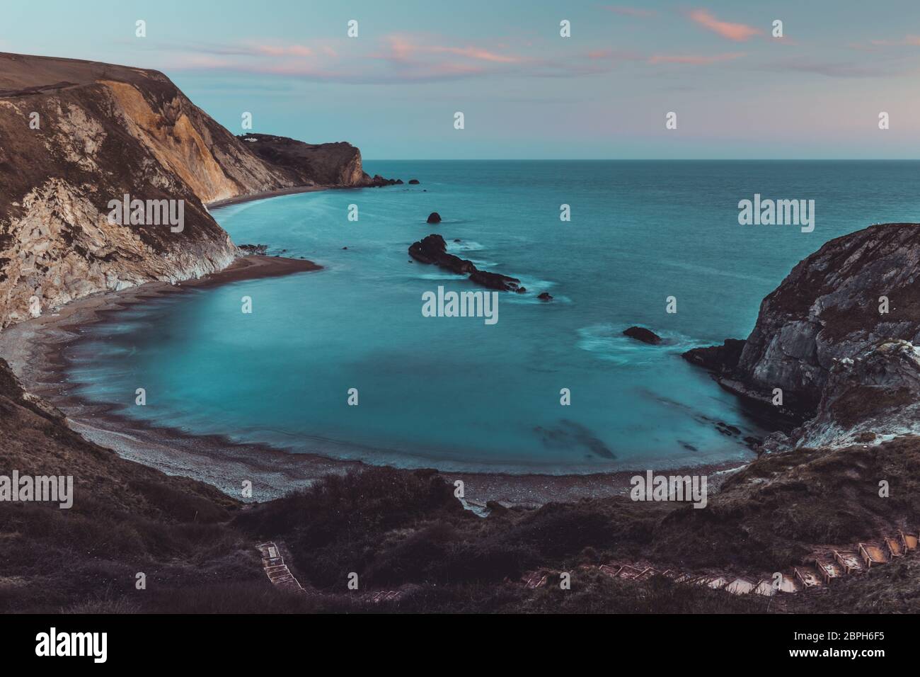 Lulworth Cove at sunset on beach in Dorset, England Stock Photo - Alamy