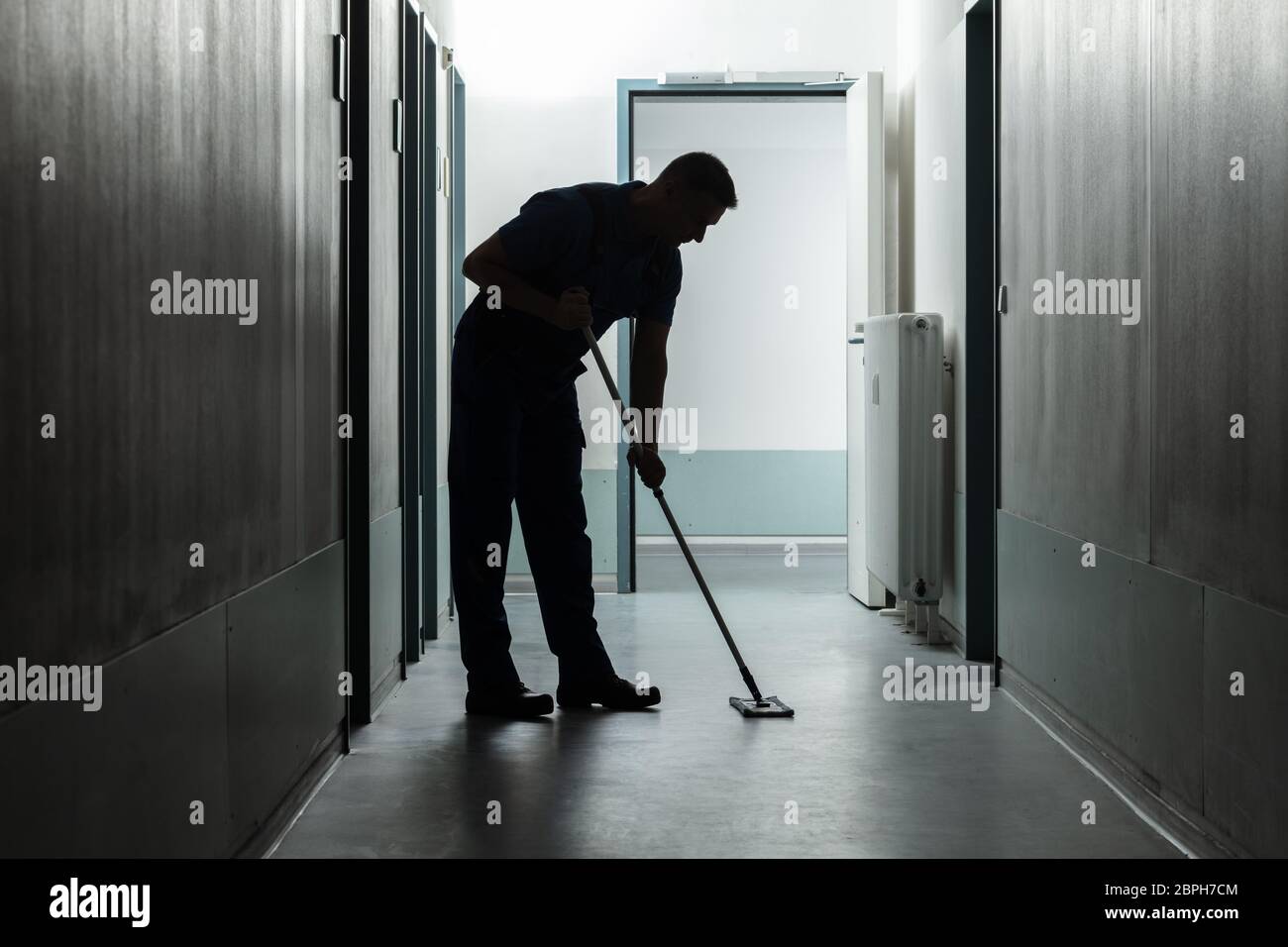 Silhouette Of A Male Janitor Cleaning Corridor Stock Photo - Alamy