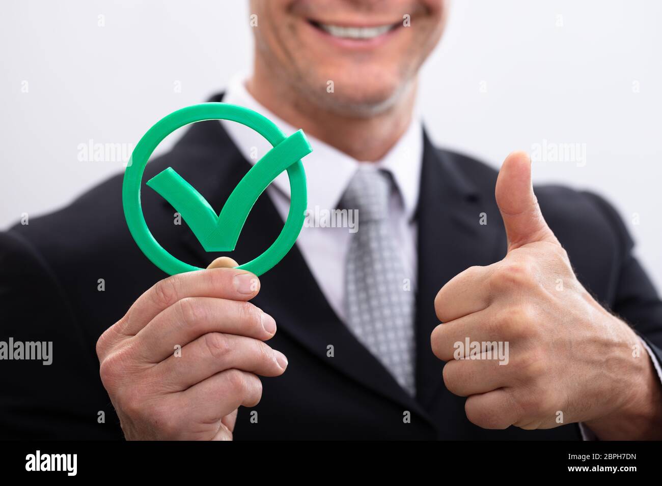 Close-up Of A Businessman Hand Holding Green Check Mark Icon Stock ...