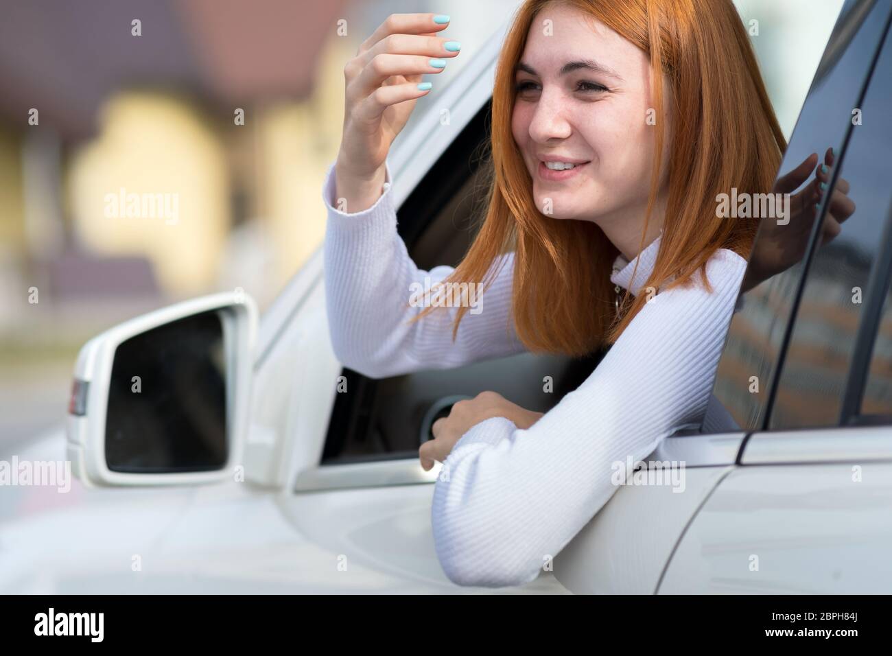 Young woman with red hair driving a car Stock Photo - Alamy
