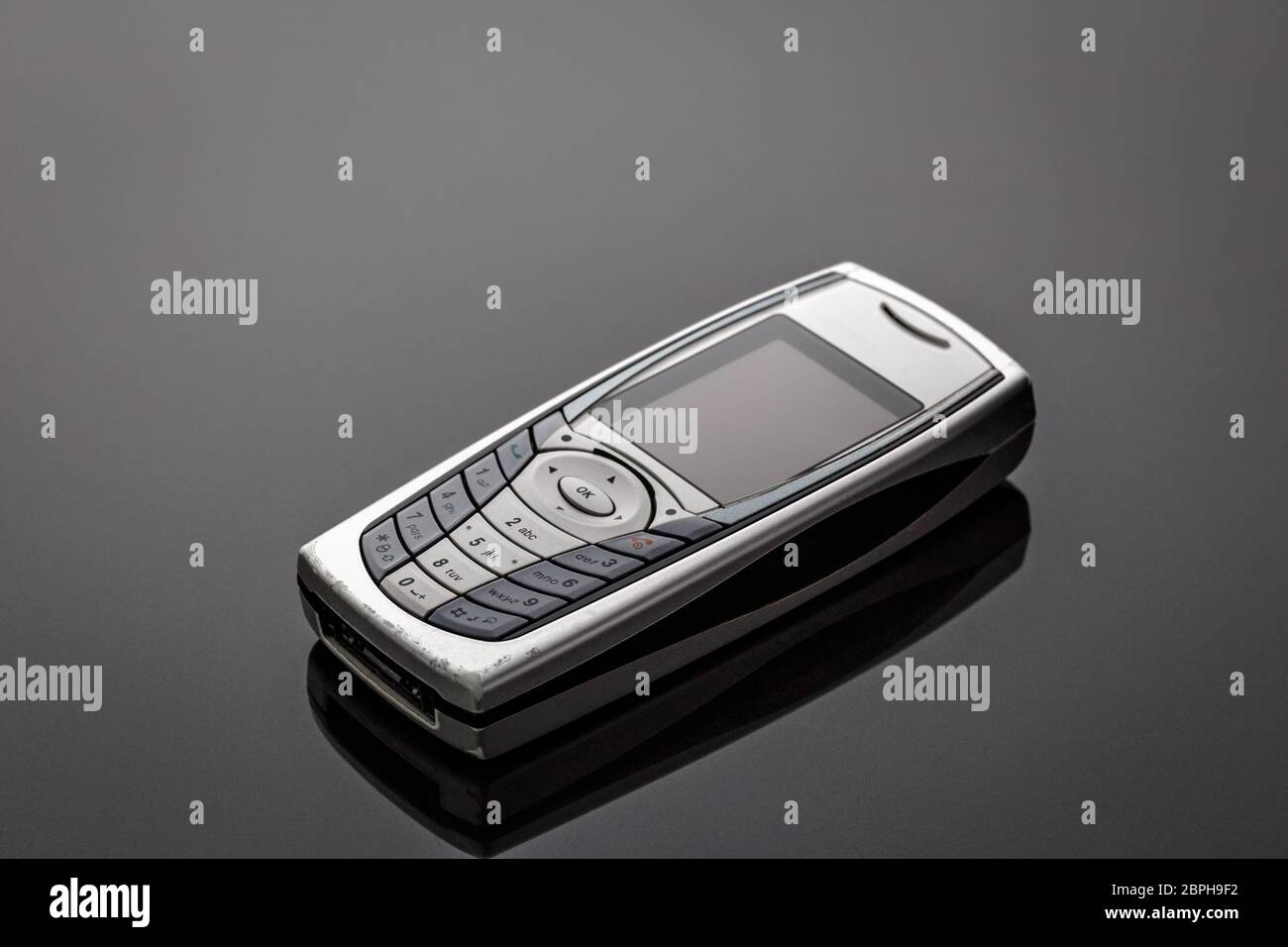 Old worn old-fashioned mobile phone on a gray background Stock Photo ...