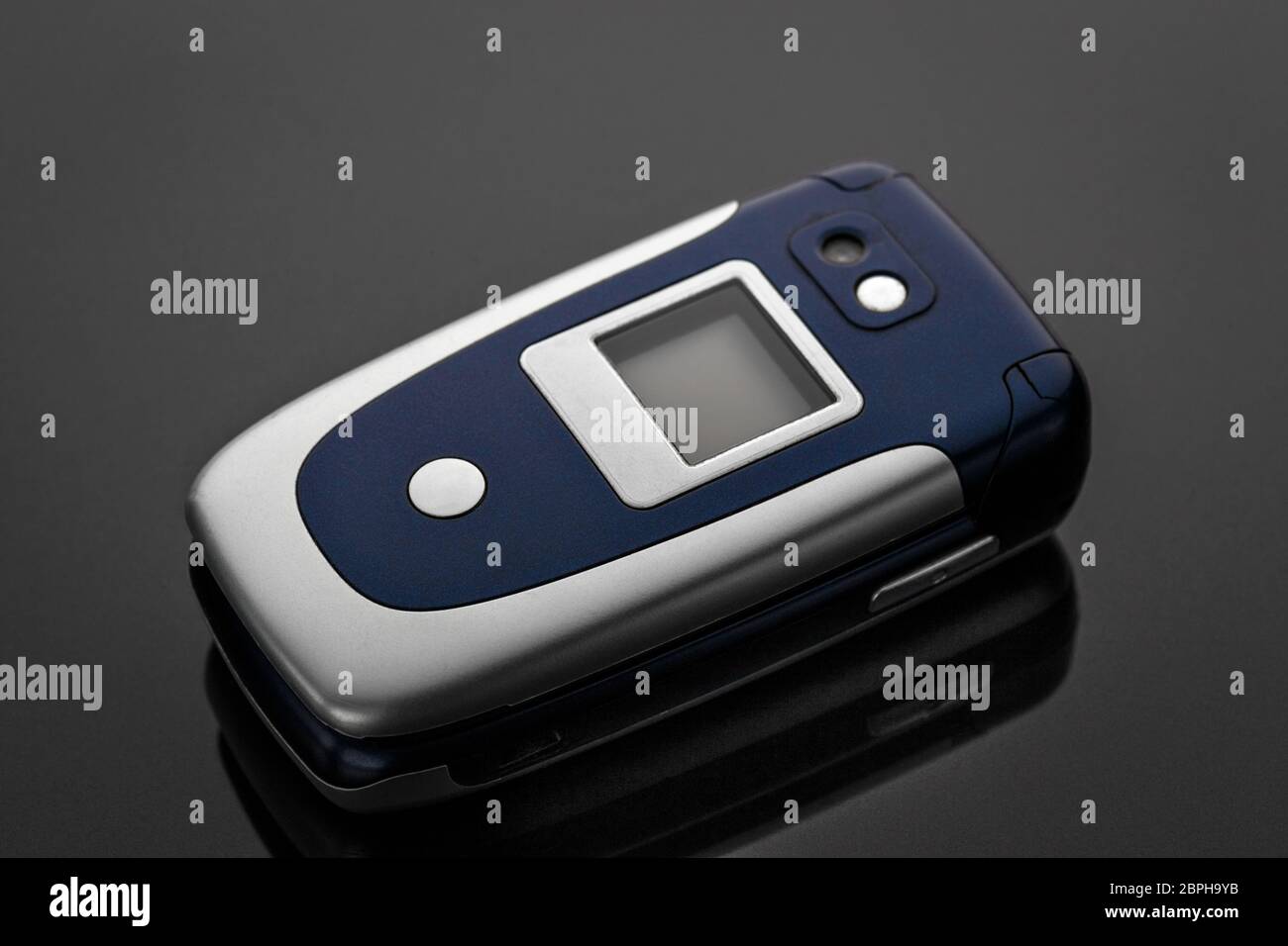 Old battered and scratched mobile phone on a gray background with ...