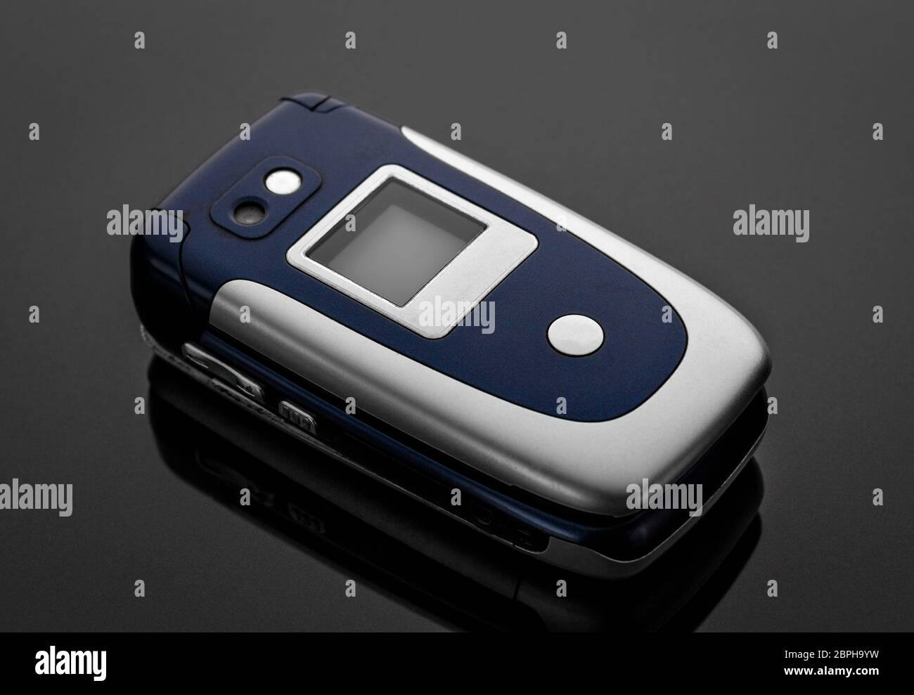 Old battered and scratched mobile phone on a gray background with ...