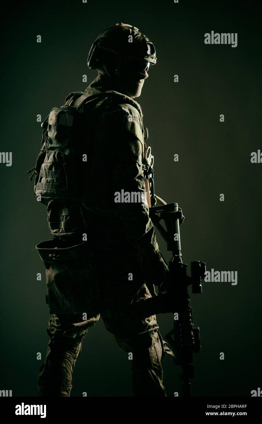 Low key studio shoot of army special forces soldier, commando fighter ...