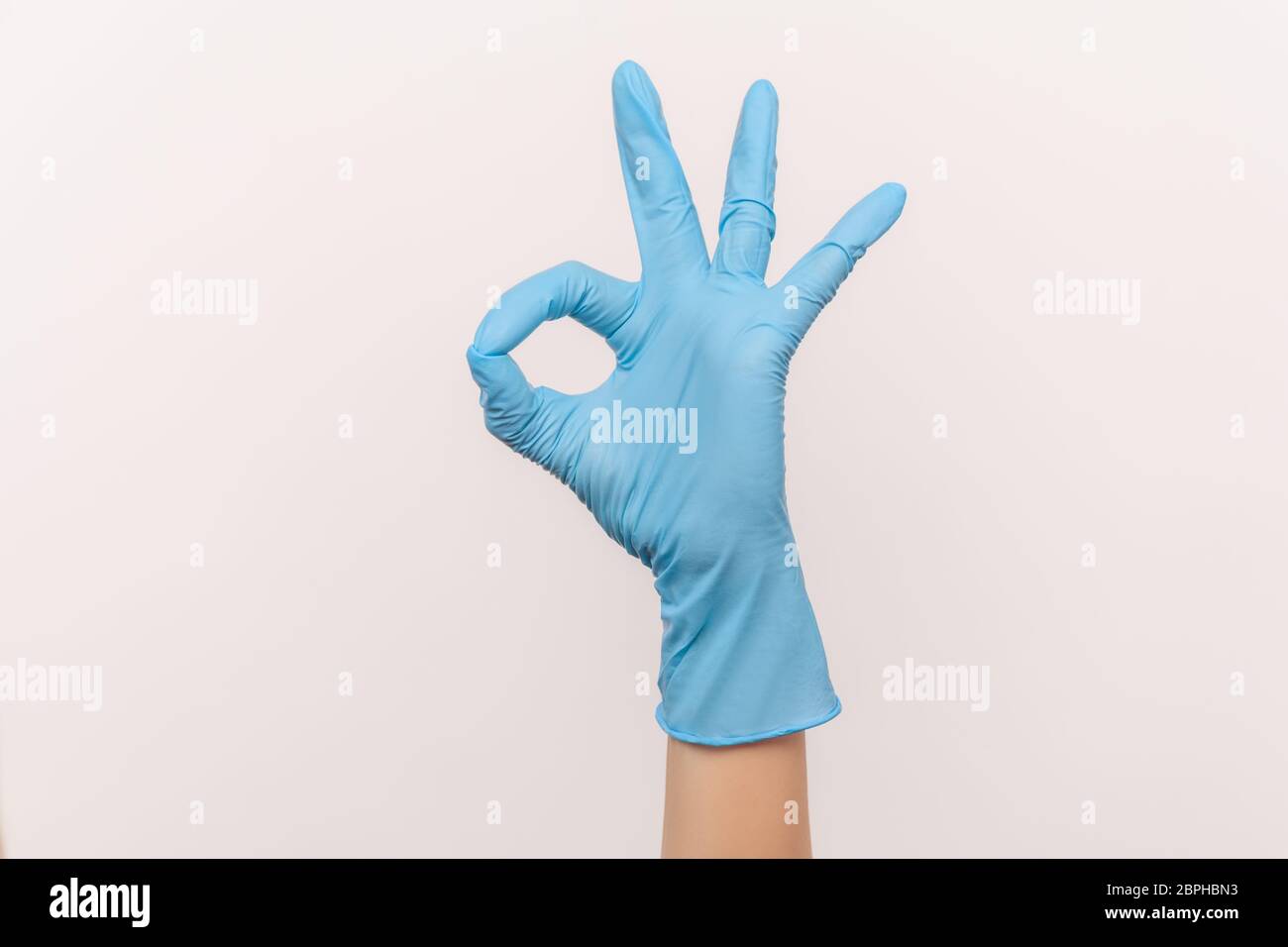 Profile side view closeup of human hand in blue surgical gloves showing ...