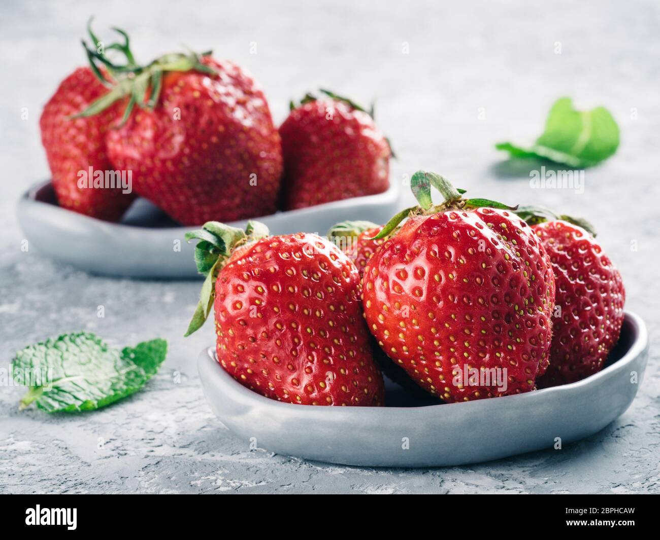 Fresh ripe strawberries in small trendy plate. Strawberry in gray plate ...