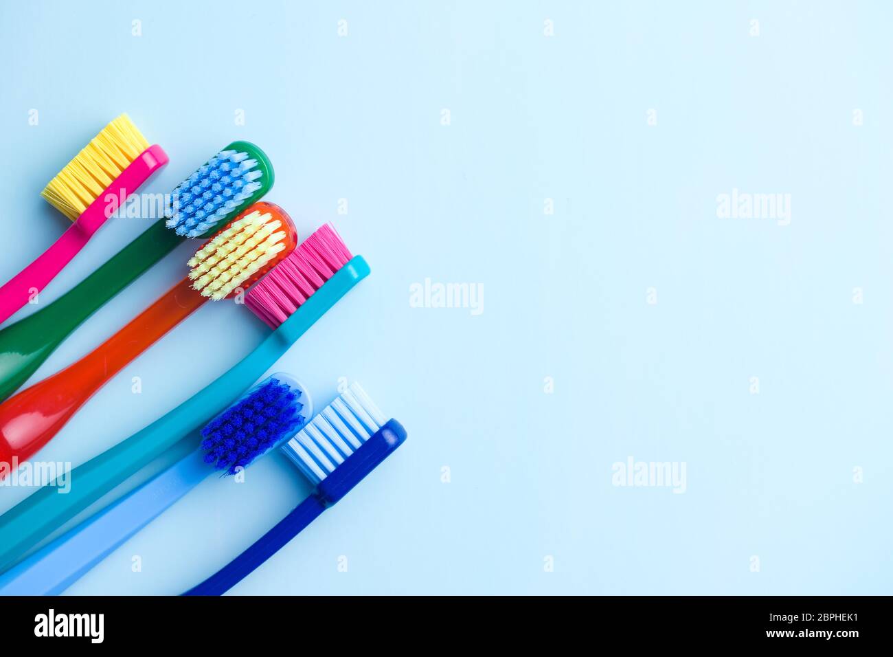 Colorful toothbrushes on blue background Stock Photo - Alamy