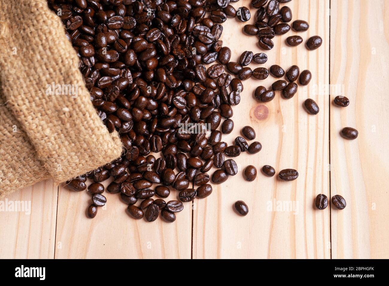 Coffee beans spilled out from burlap sack Stock Photo - Alamy