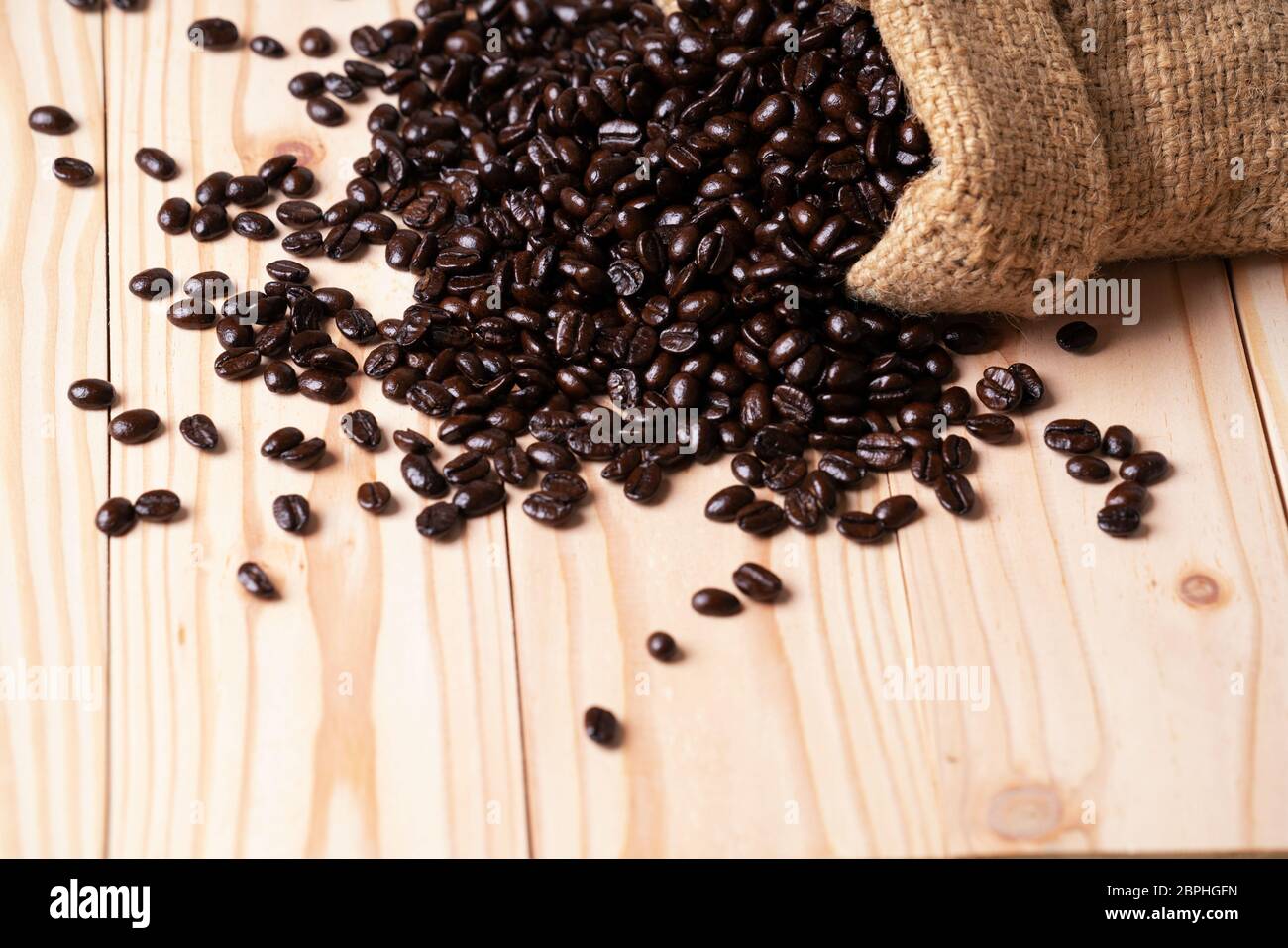 Coffee beans spilled out from burlap sack Stock Photo - Alamy