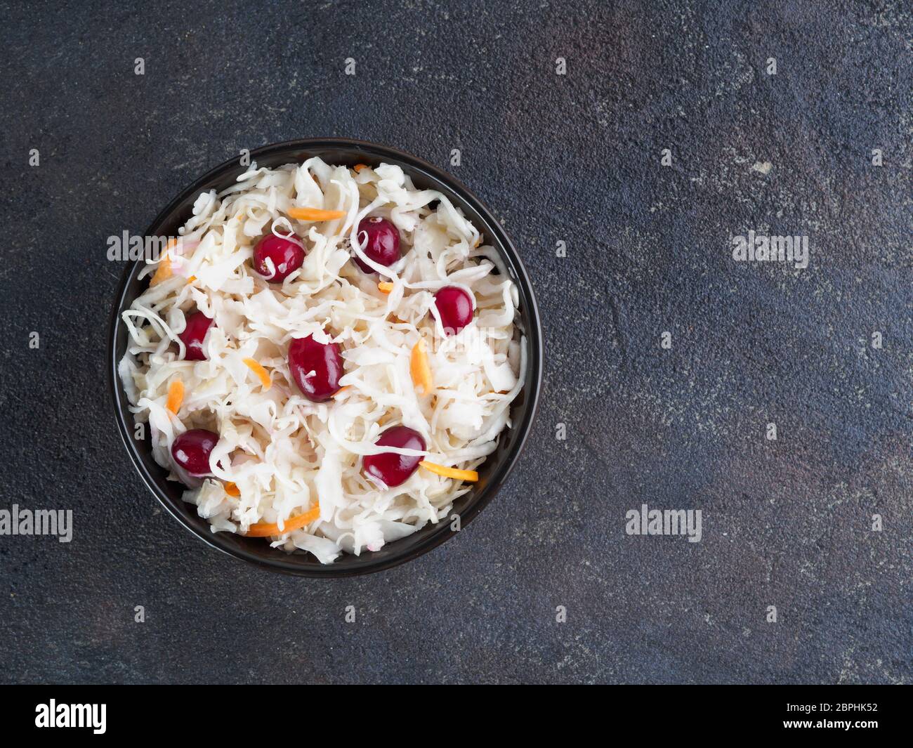 Traditional russian appetizer sauerkraut with cranberry and carrot in ...