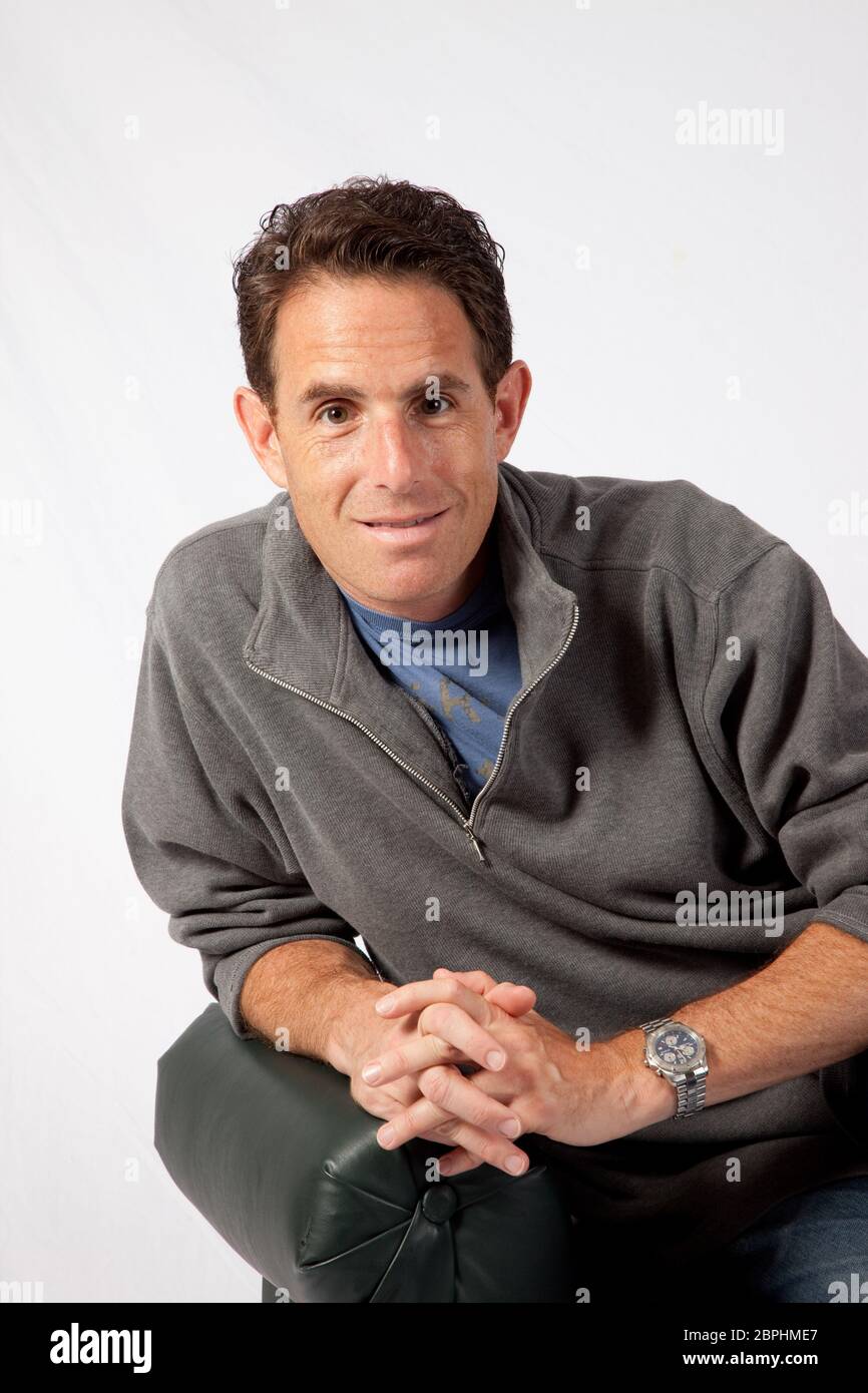 Happy man sitting with a smile Stock Photo - Alamy