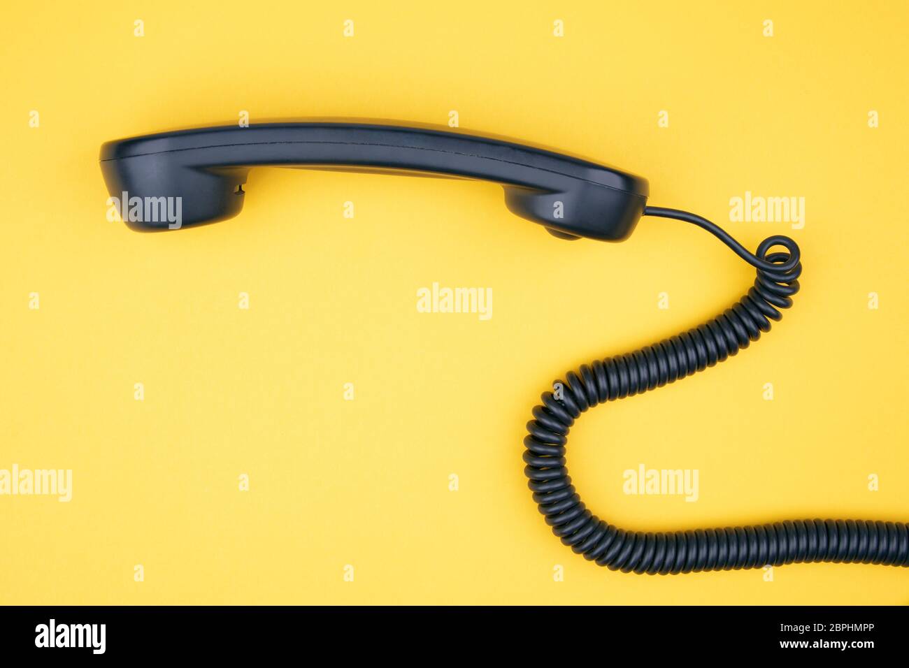 Black Phone Receiver on yellow Background Stock Photo - Alamy