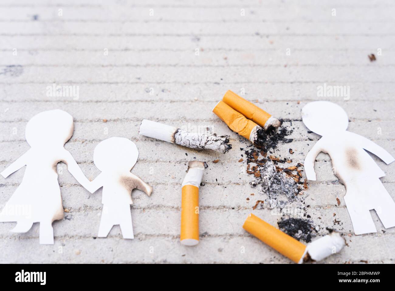 Paper cut of family members destroyed by cigarette. Smoking destroying ...
