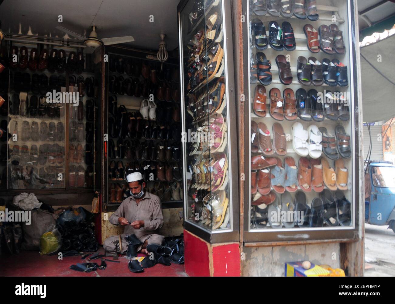 Peshawar, Pakistan. 19th May, 2020. A Pakistani shoemaker makes ...