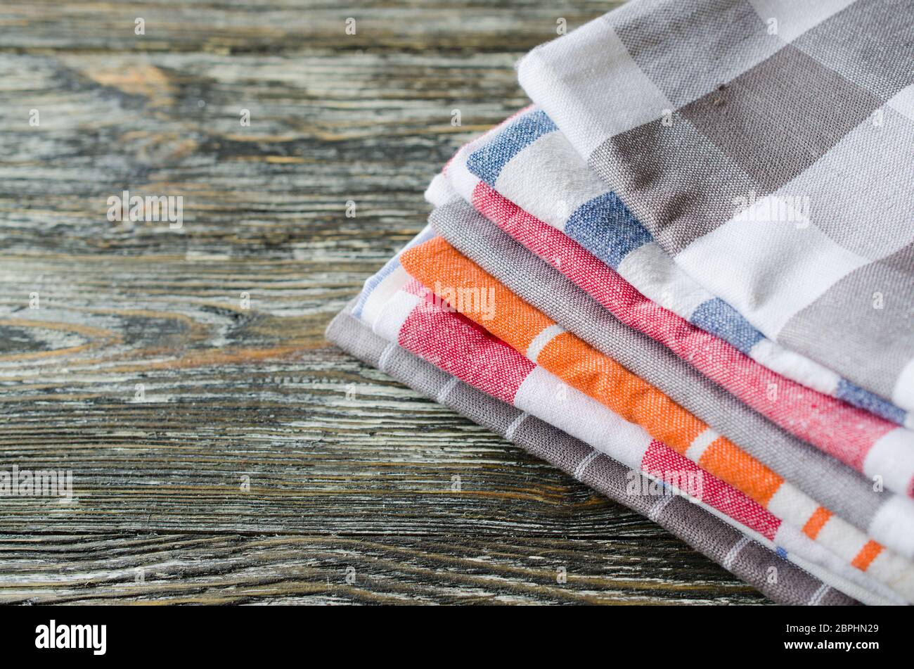 Stack of kitchen towels or napkins over the rustic wooden table. View ...