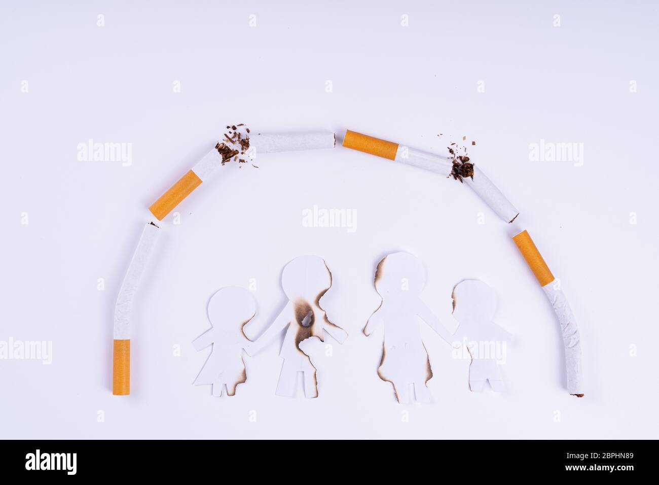 Paper cut of family members destroyed by cigarette on white background ...