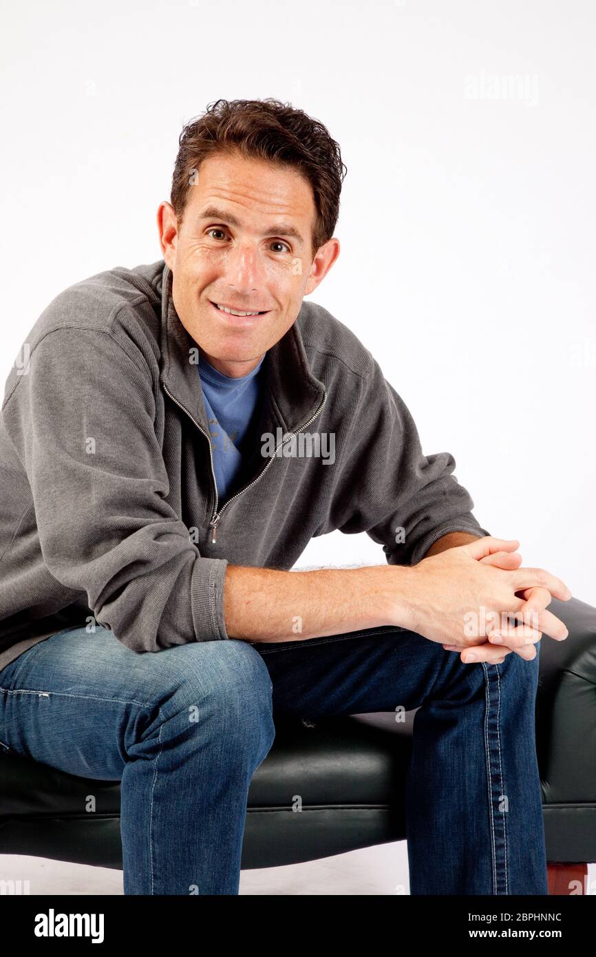 Happy man sitting with a smile Stock Photo - Alamy
