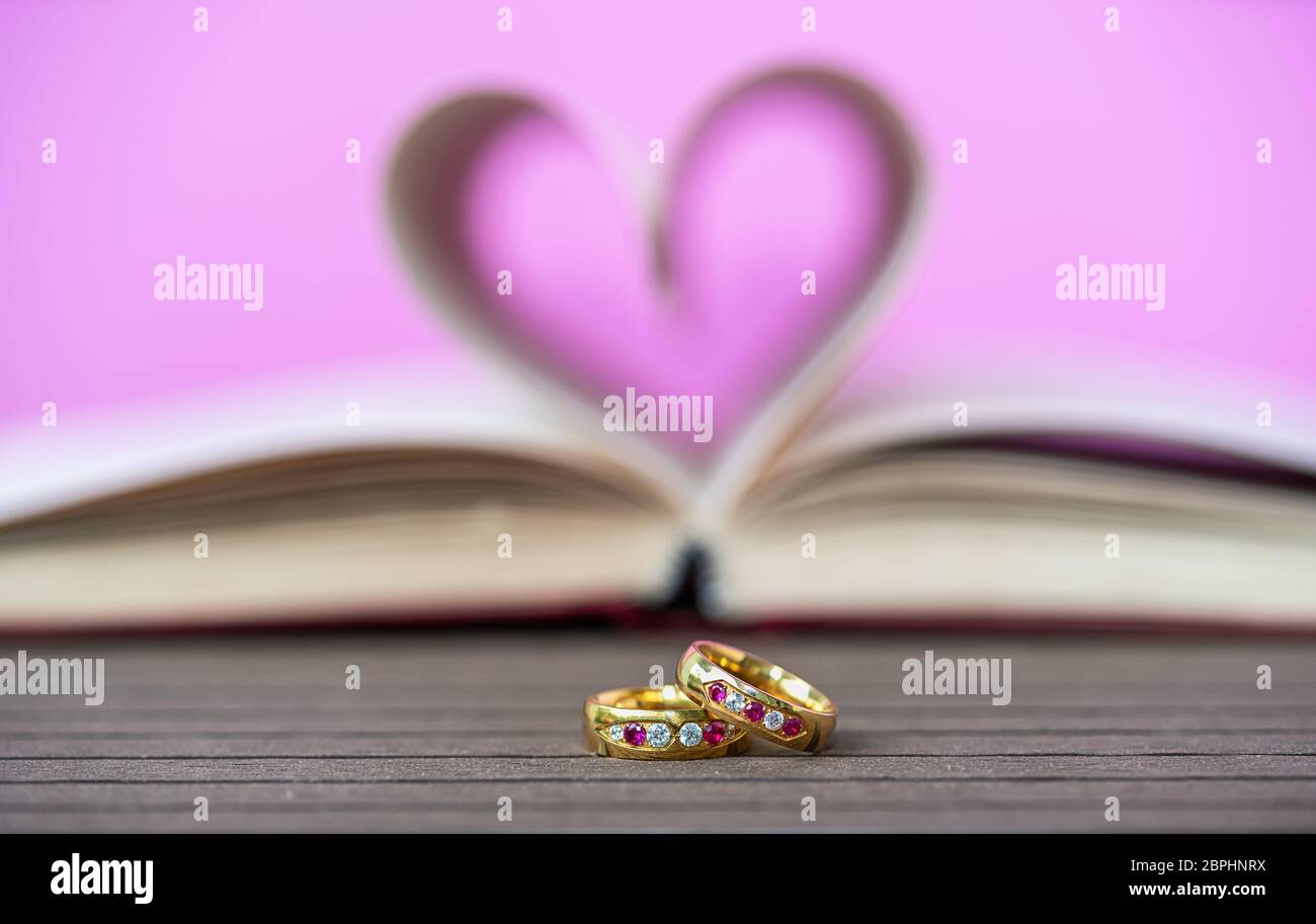 Pages of book curved into a heart shape and wedding ring . Love concept ...