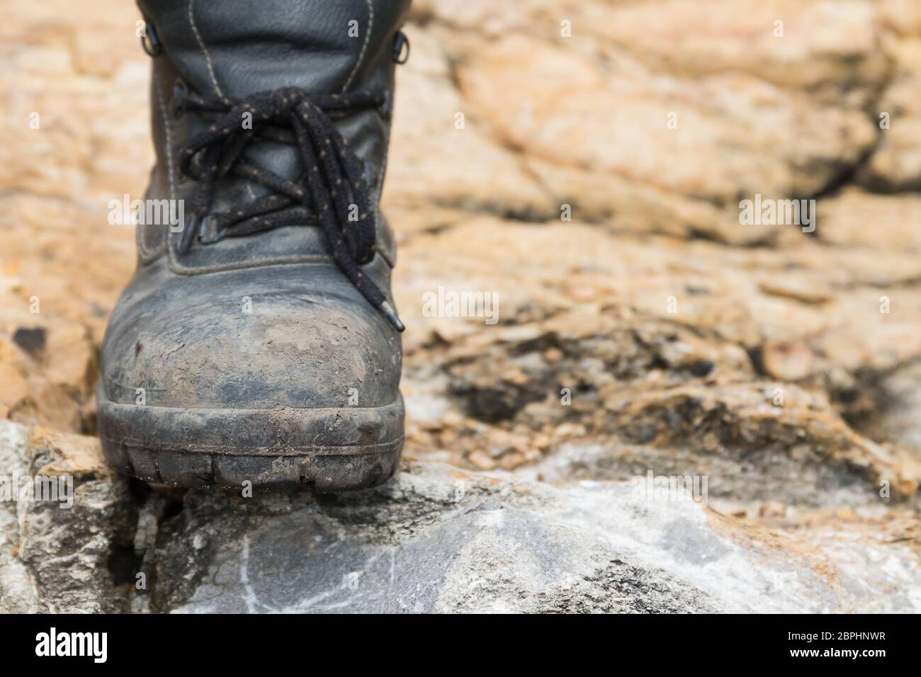 Closeup of trekking leather boot on the rock in mountain Stock Photo ...