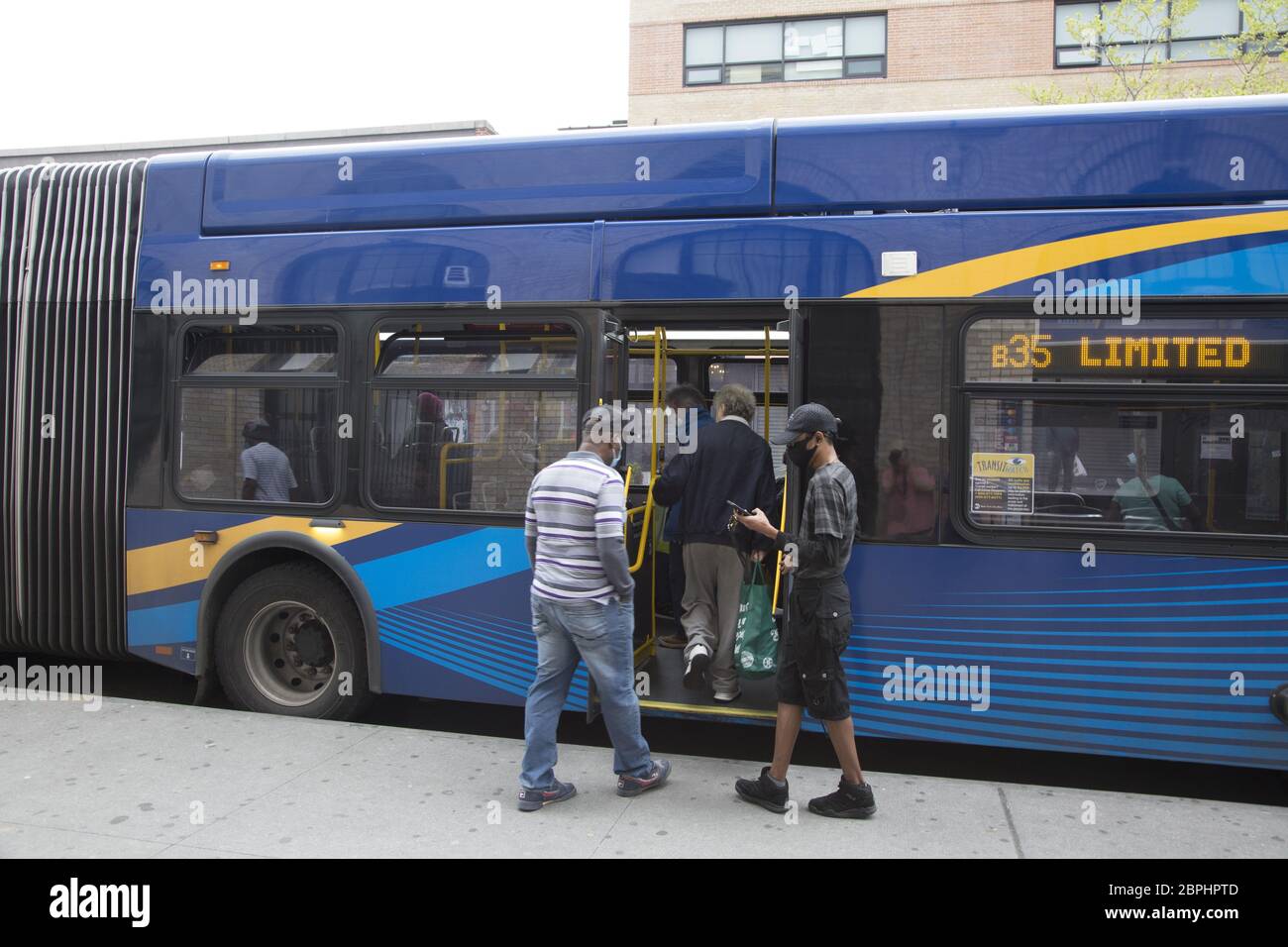 Riders enter and exit rear doors of city buses in New York City where ...