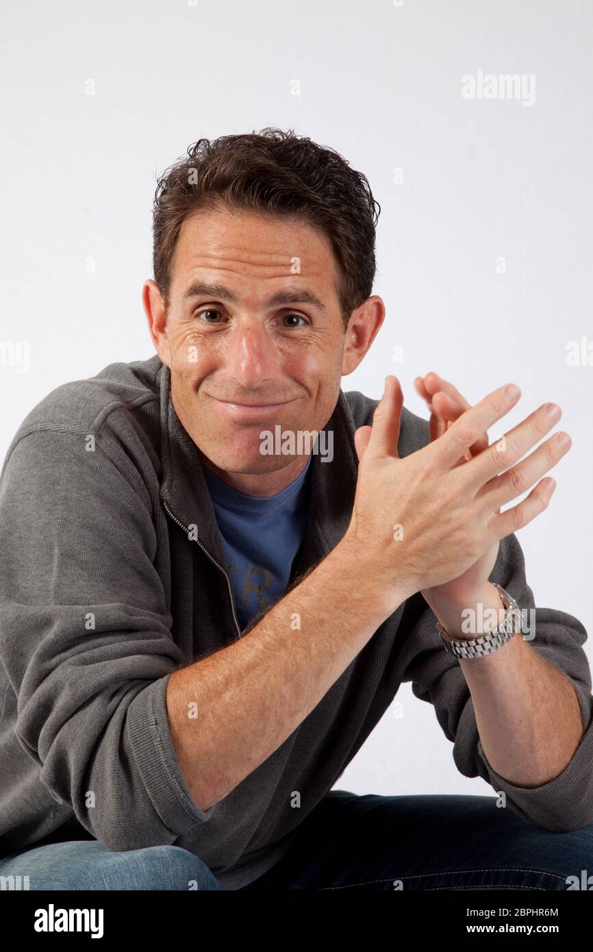 Happy man in grey shirt sitting with a smile Stock Photo - Alamy