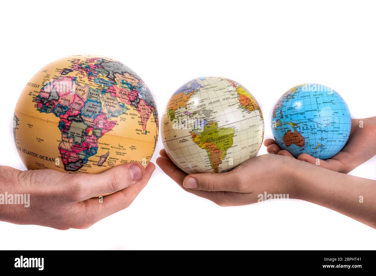 Two hands holding holding three globes in hand on white background ...