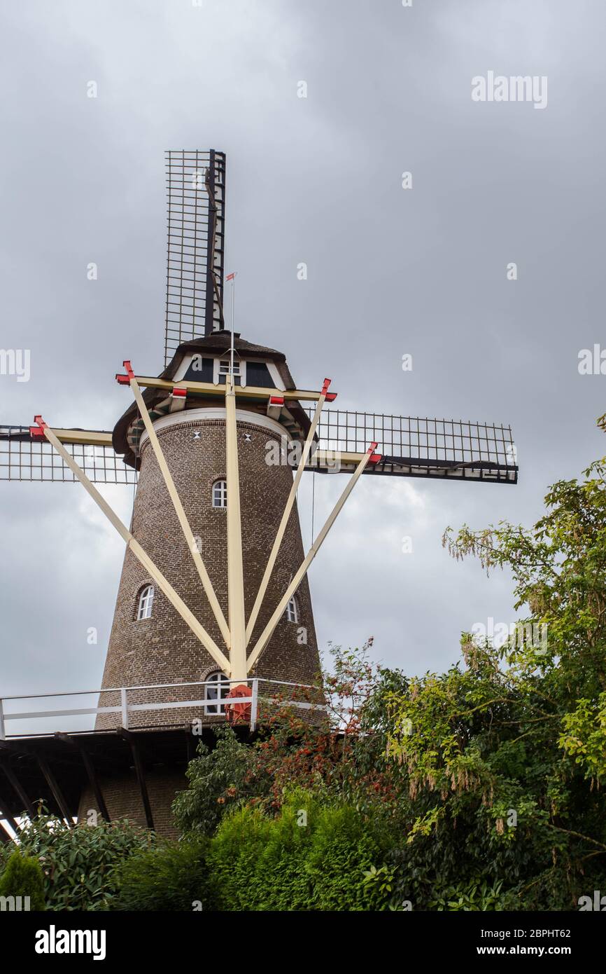 Traditional dutch windmill in the Netherlands close-up with green trees ...
