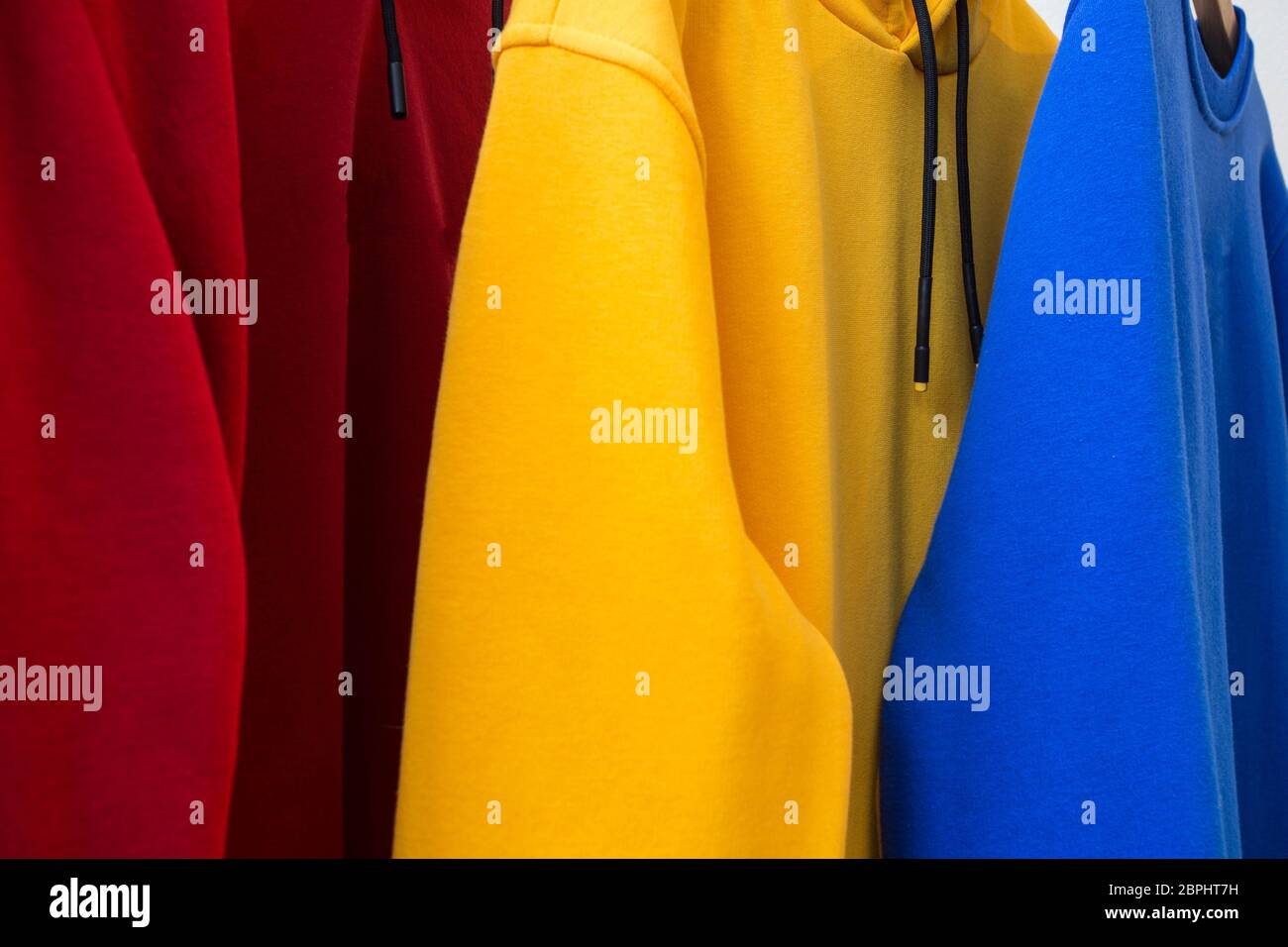 Colorful hoodies on hangers close-up modern design fabric texture Stock ...