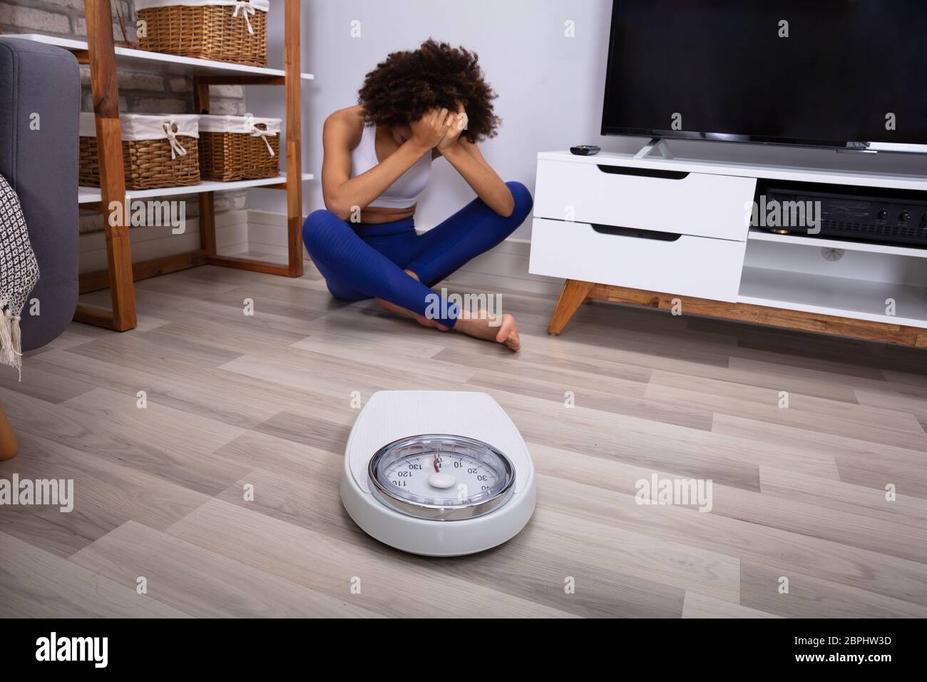 Weighing Scale In Front Of Crying Young Woman Sitting In The Living ...