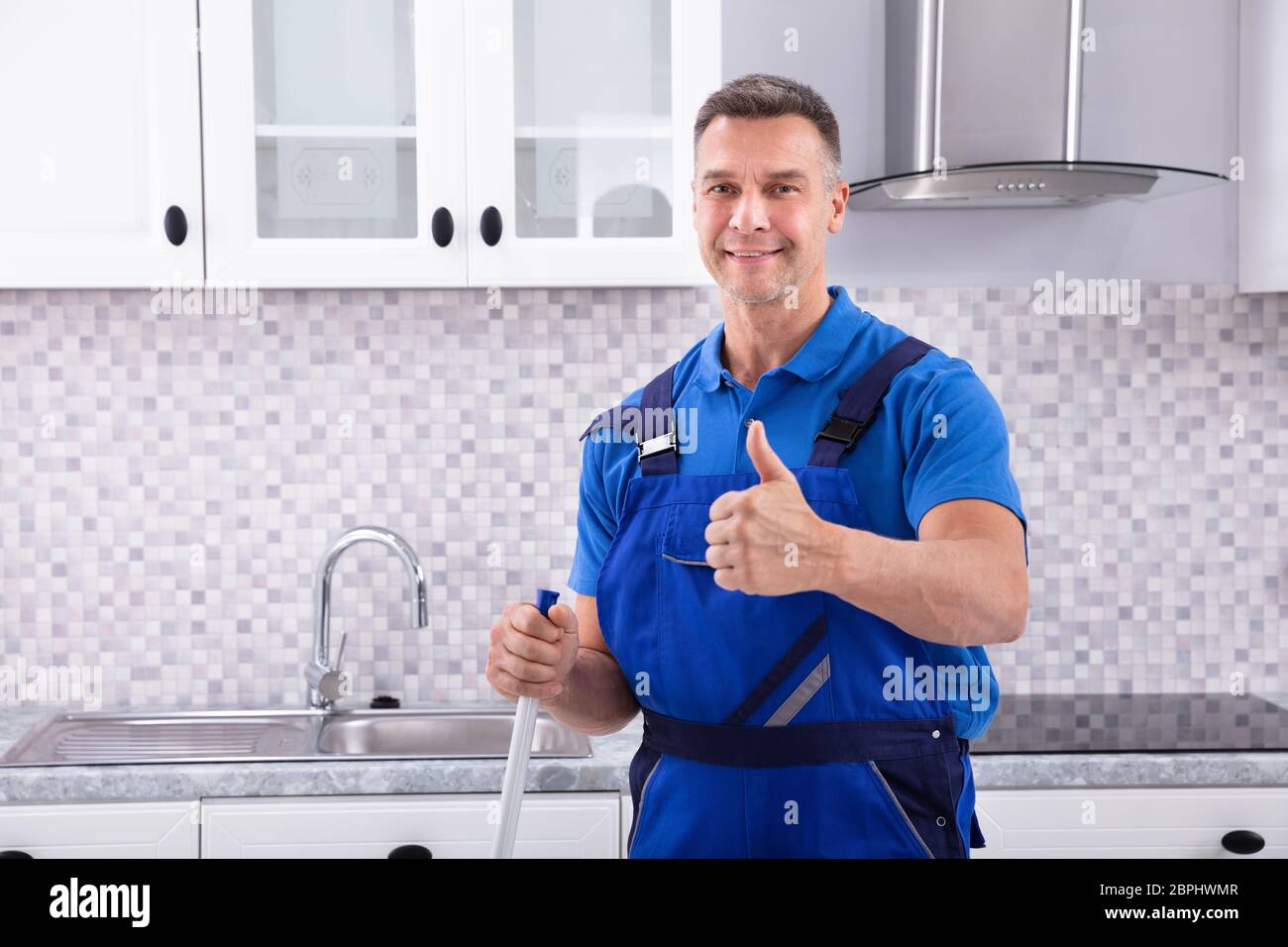 Portrait Of A Happy Male Janitor Gesturing Thumbs Up In Kitchen Stock ...