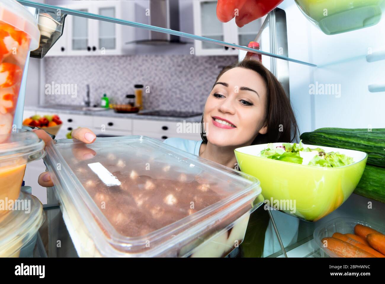 Woman taking cake from fridge hi-res stock photography and images - Alamy