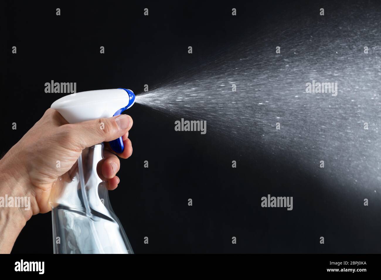 Human Hand Spraying Detergent With Spray Bottle On Black Background ...