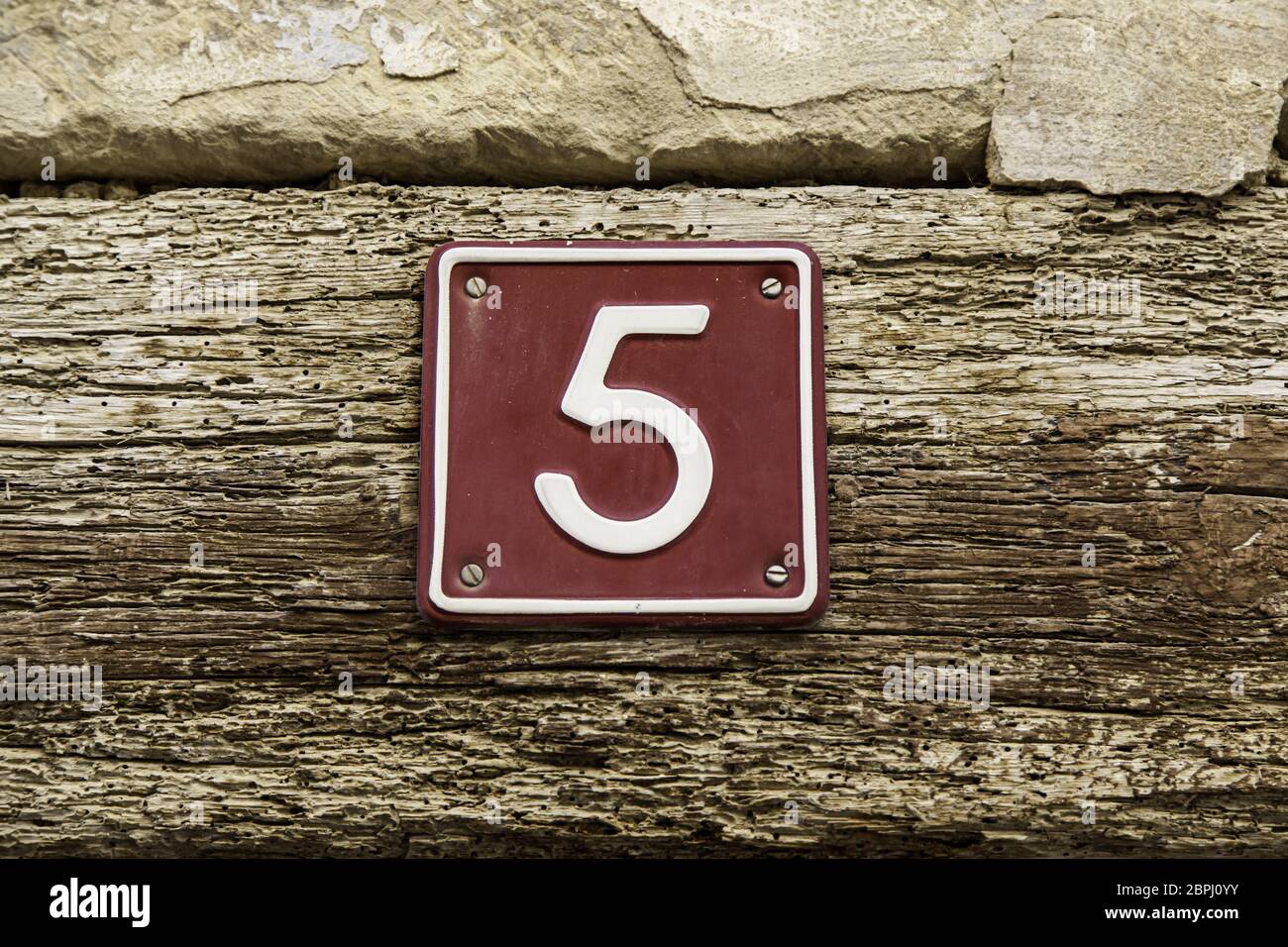 Number five information on the wall of a house, detail of odd number ...
