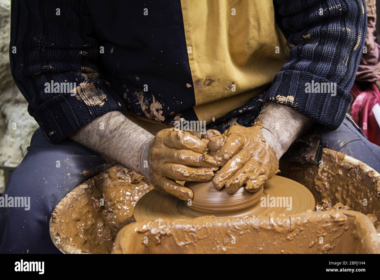 Hands of man working and shaping clay, potter in pottery, craft detail ...