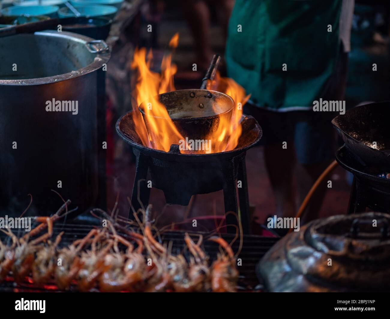 Chef cooking with fire with frying pan Stock Photo - Alamy