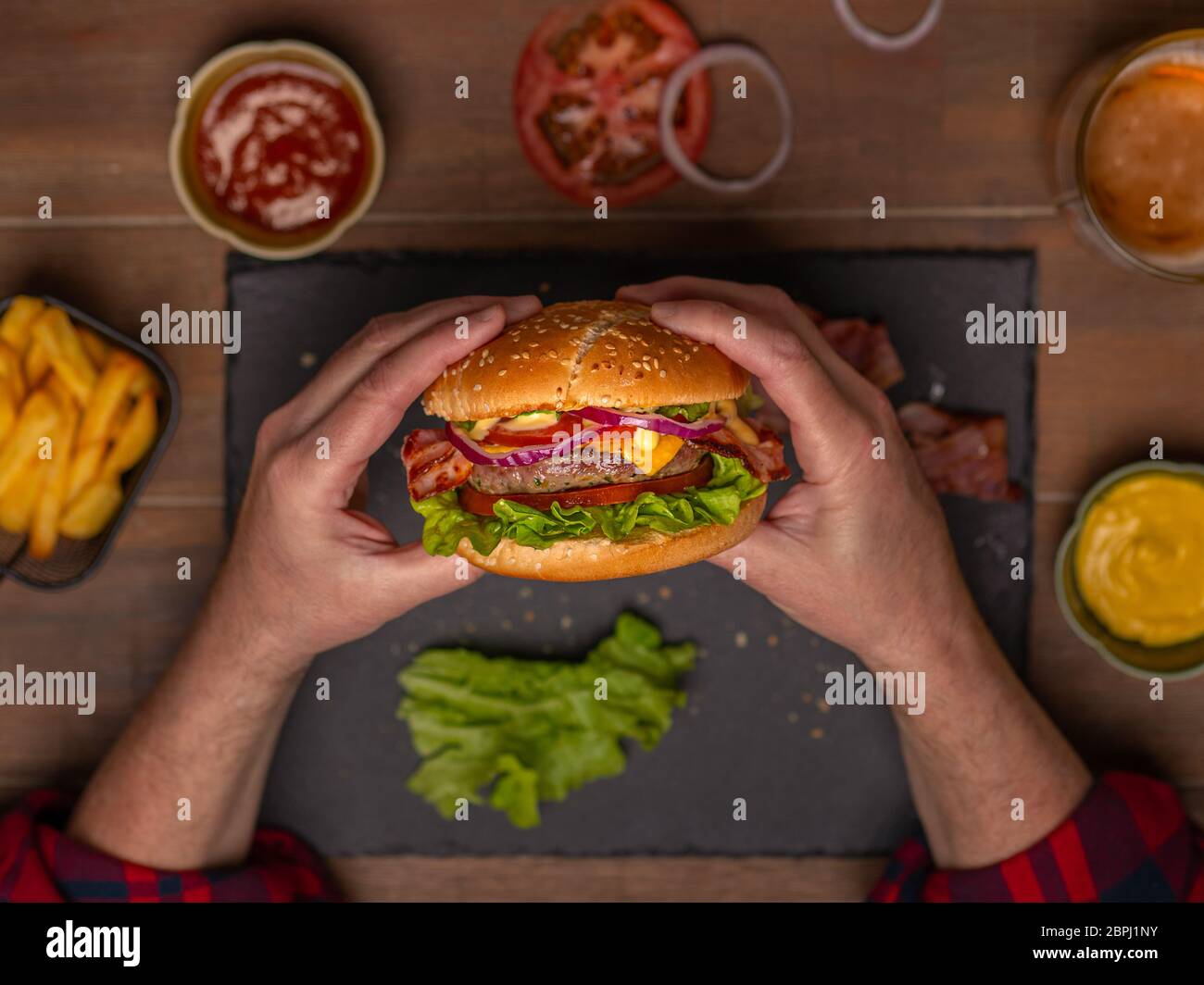 Man eating beef cheese burger with french fries Stock Photo - Alamy